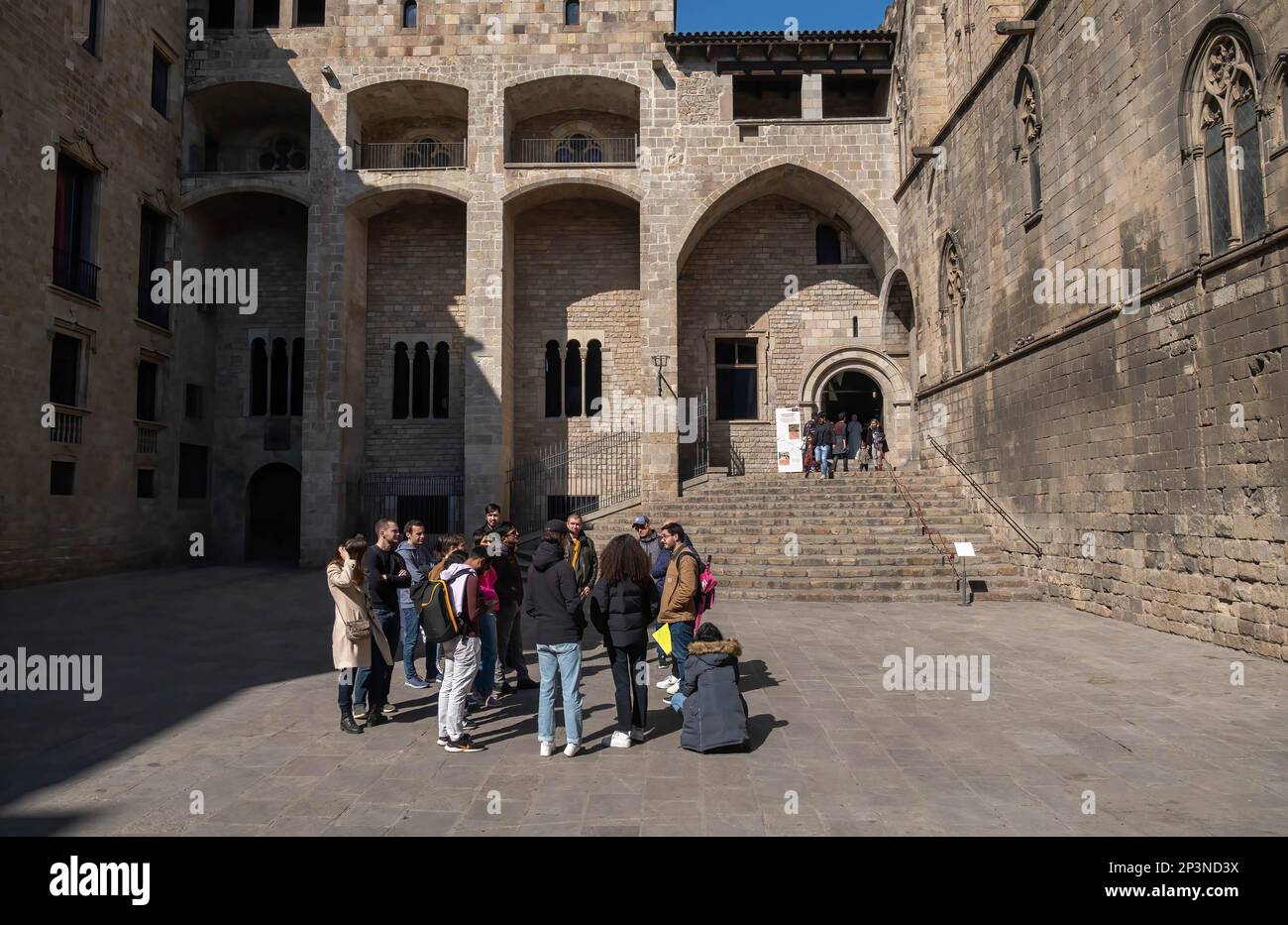 A group of people seen in PlaÁa del Rei attending the explanations of a ...