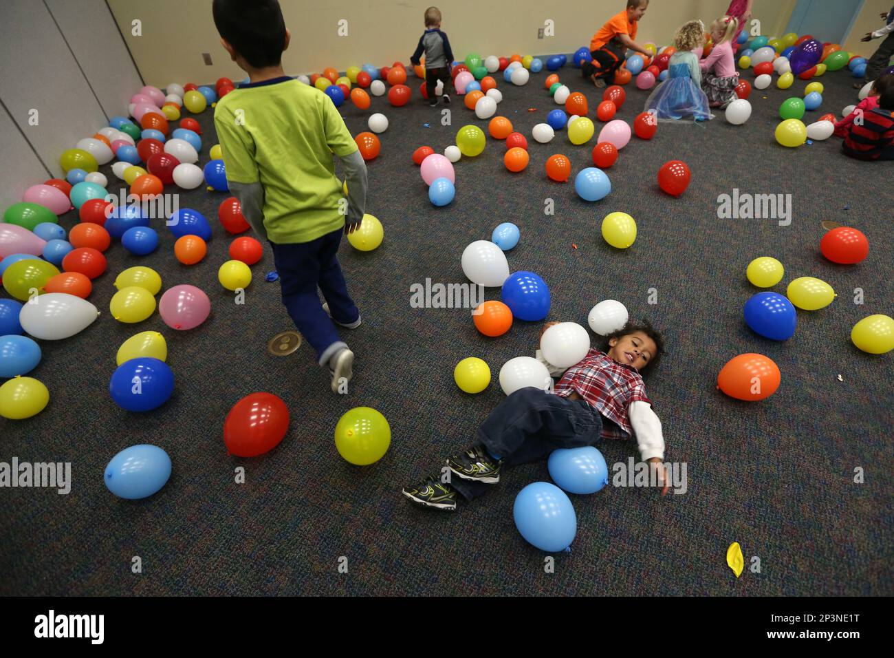 Aiden Callahan, 4, rolls around a room full of balloons Wednesday, Dec ...