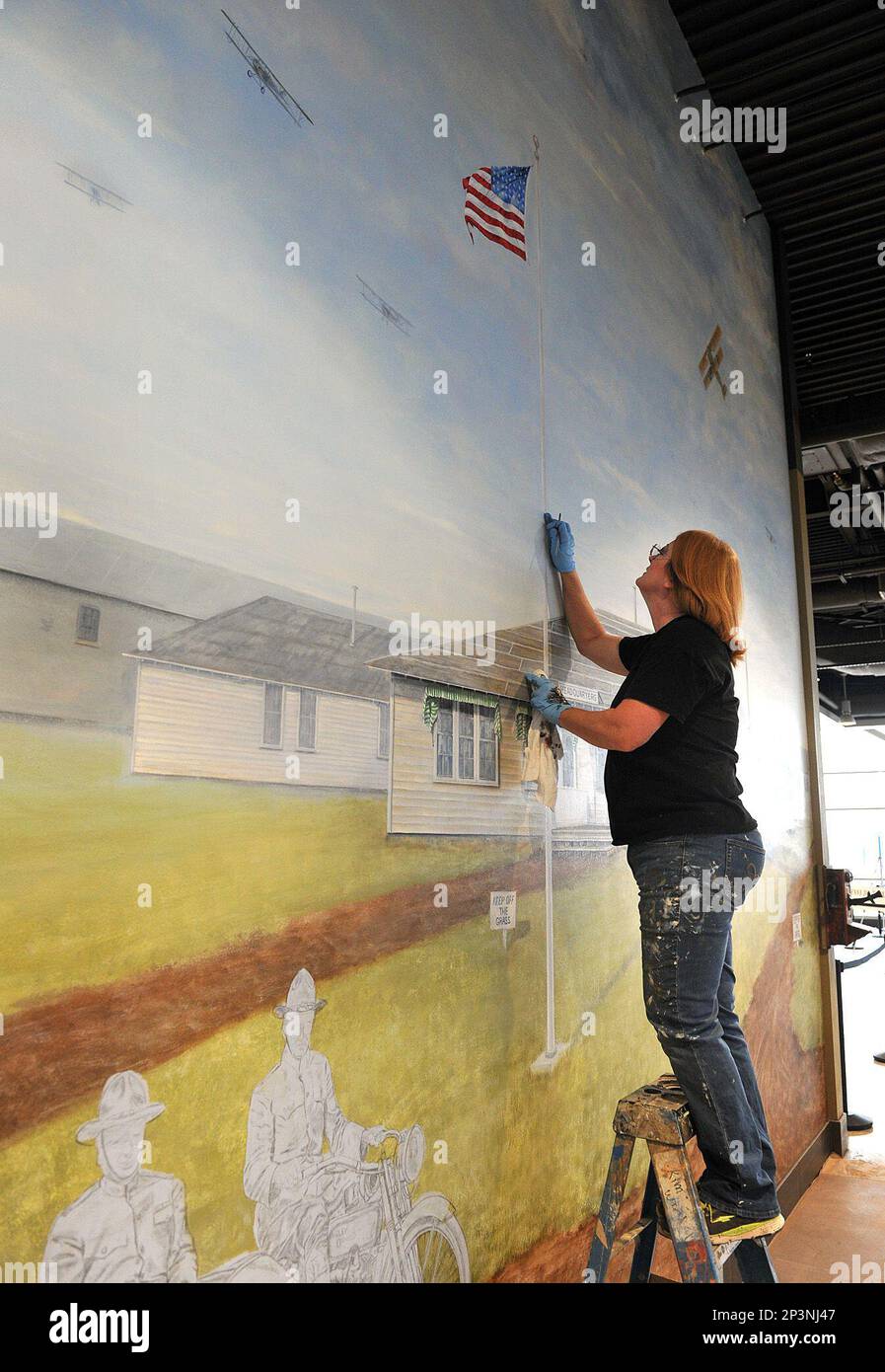 Local artist Kim Ward touches up a spot on the flagpole of the Call ...