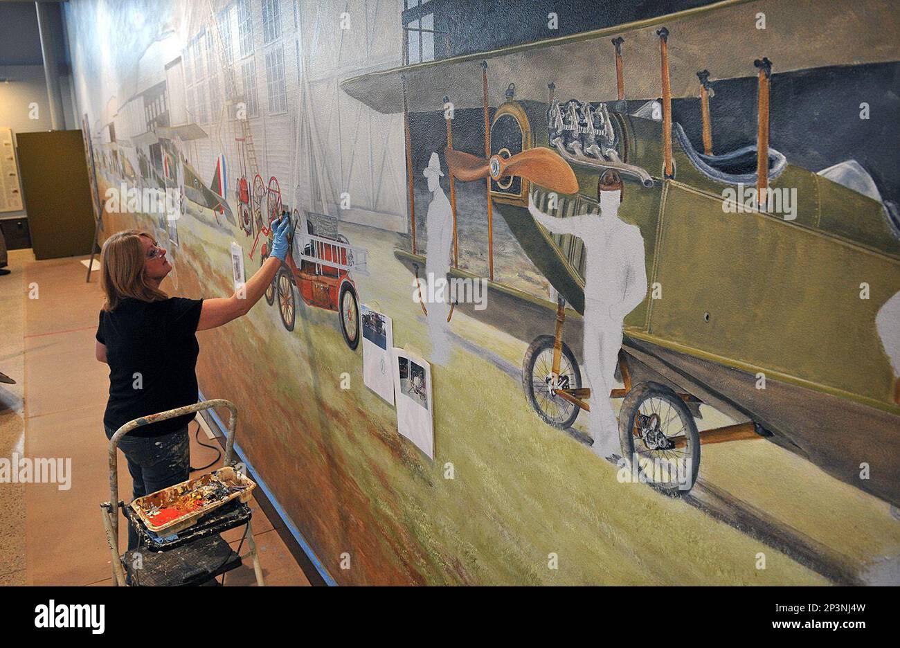 Artist Kim Ward works on the diorama mural for the Jenny To Jet exhibit ...
