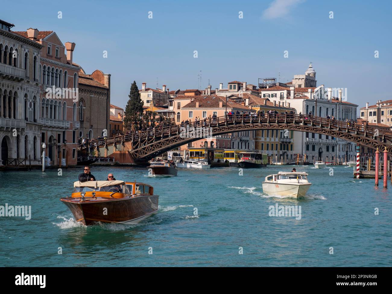 Water taxis and small boats pass under the Accademia bridge on the ...