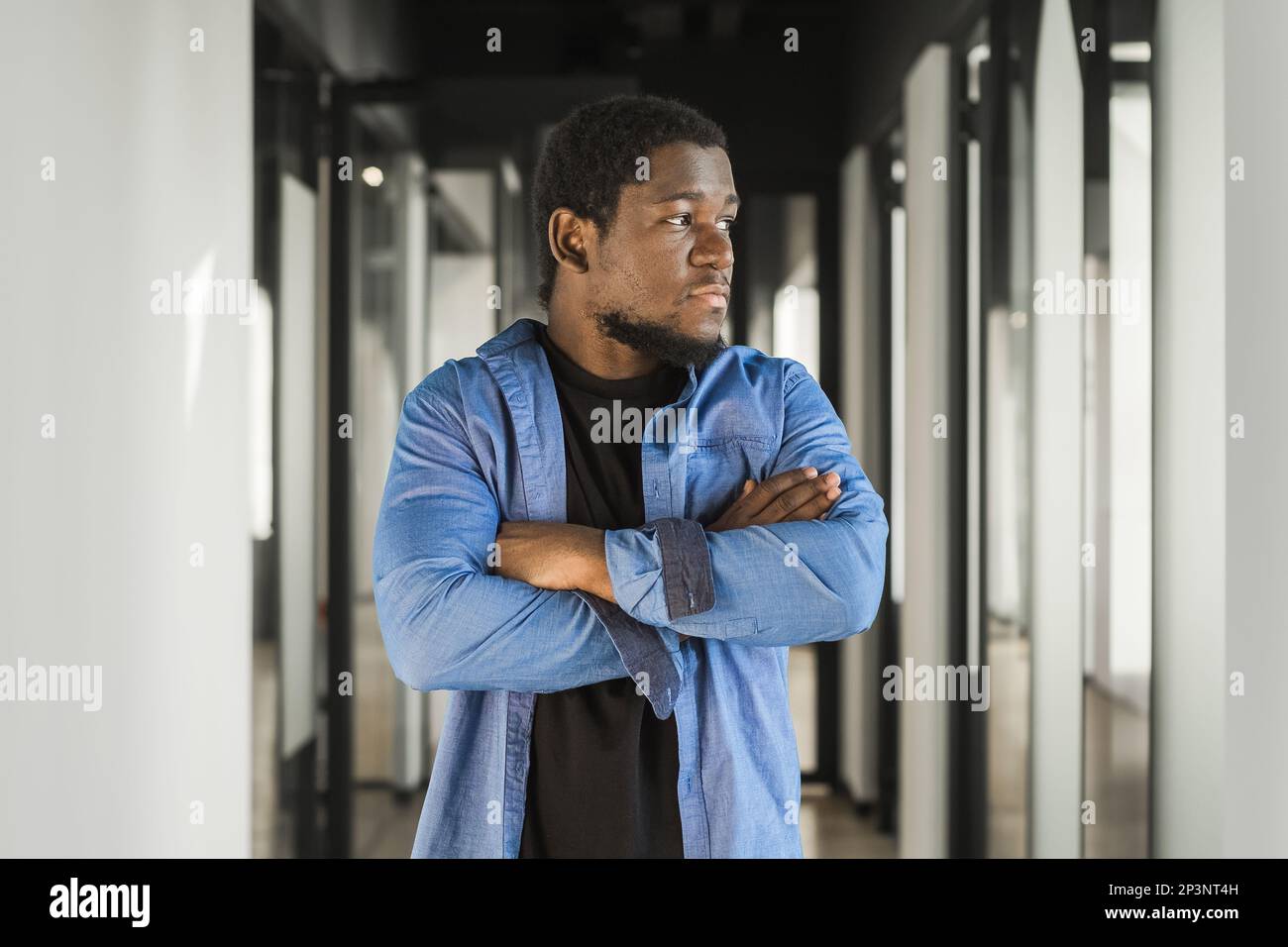 Close-up black serious male face in profile. Man stand with arms folded ...