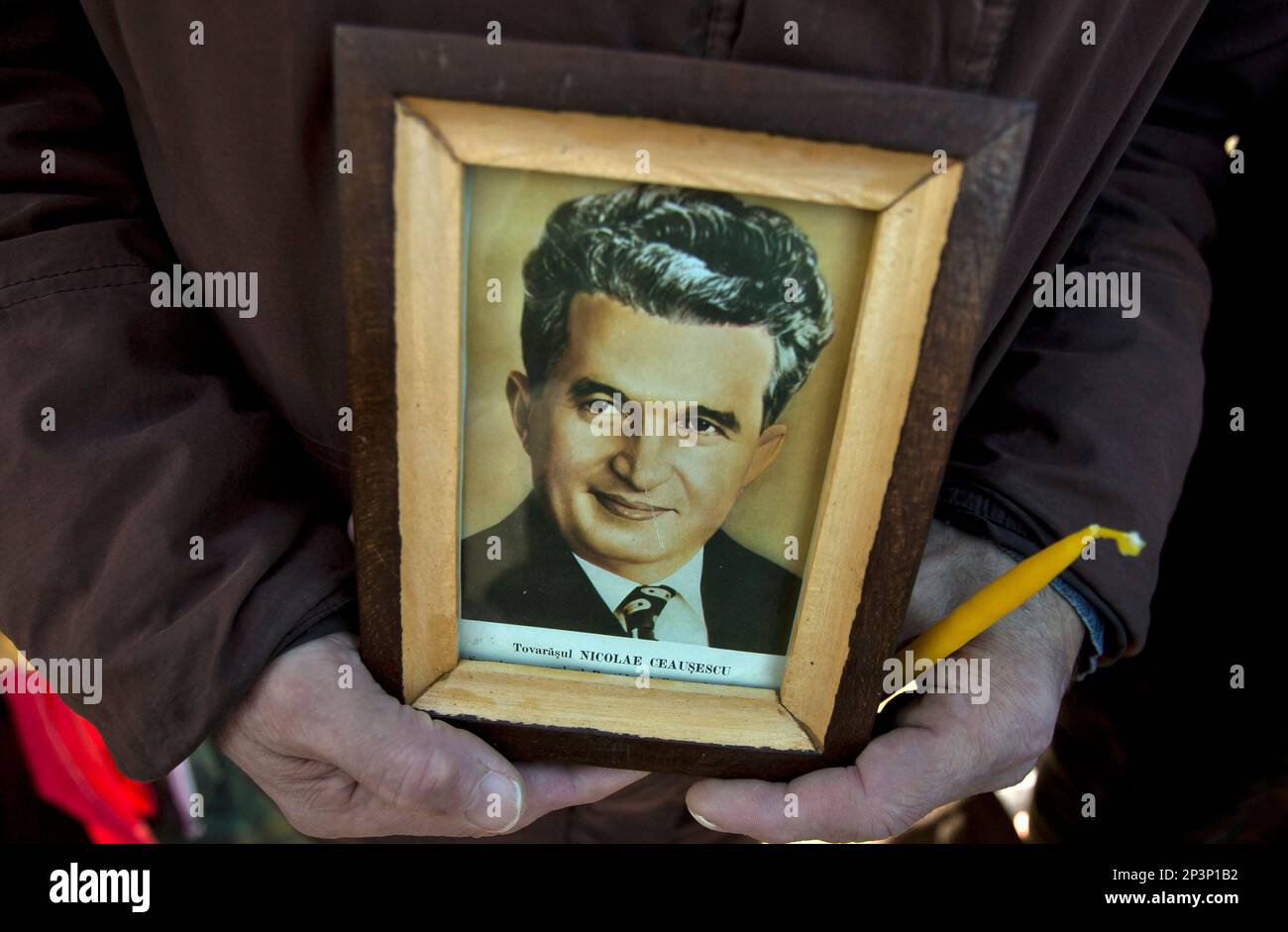 A man holds a framed picture of Romanian communist dictator Nicolae ...
