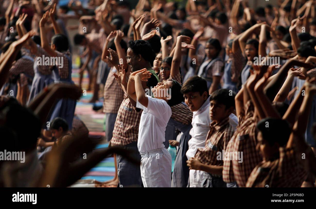 Indian school childern perform Surya Namaskar or sun salutation during ...