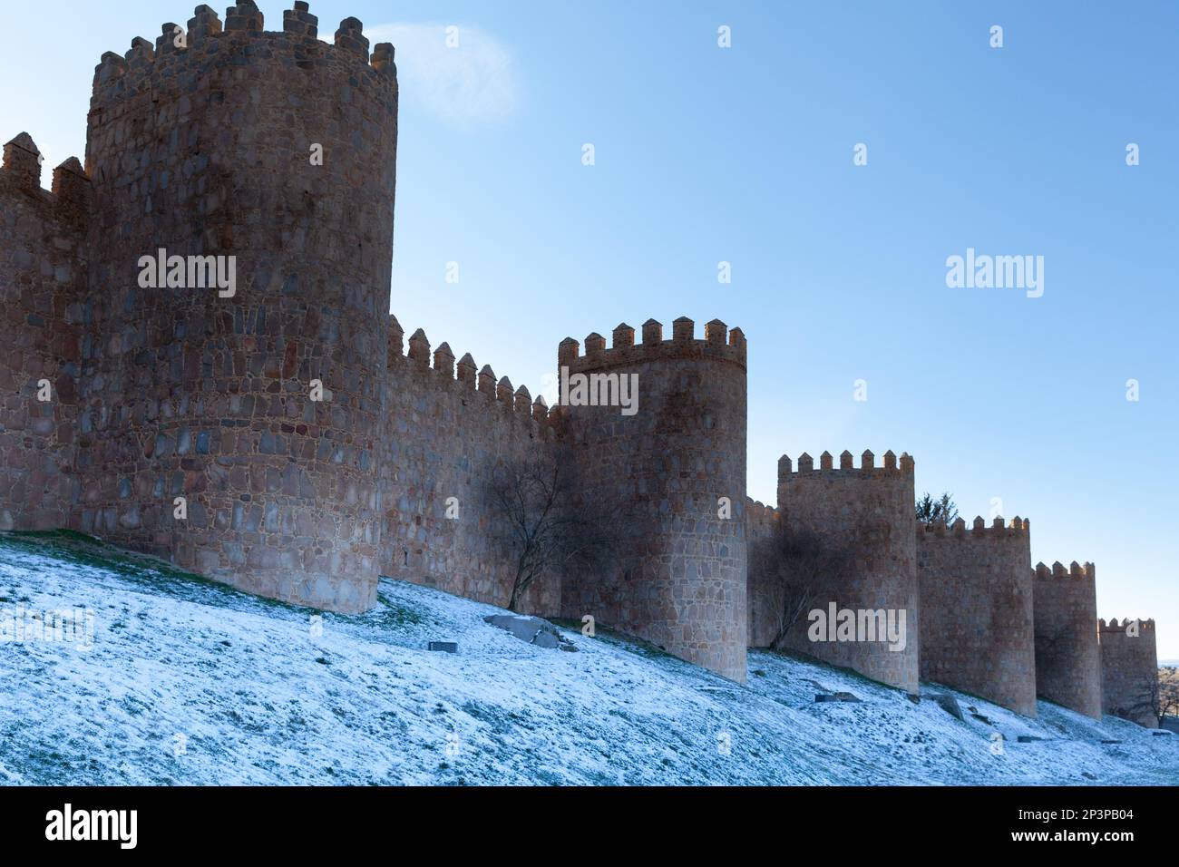 Avila, Spain - 6 January 2021: Medieval wall of Avila covered with snow ...