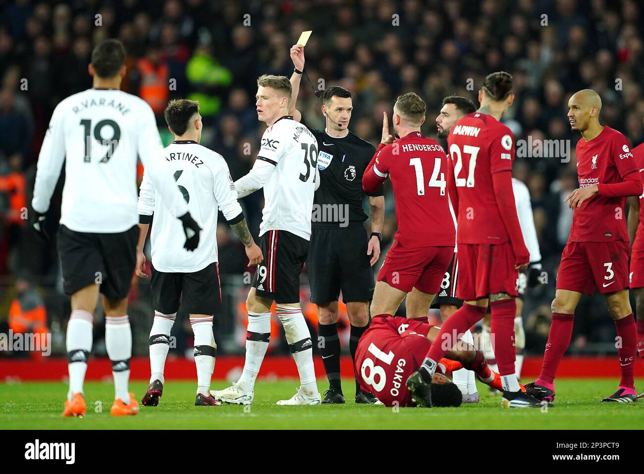 Referee Andrew Madley shows a yellow ard to Manchester United's Raphael ...