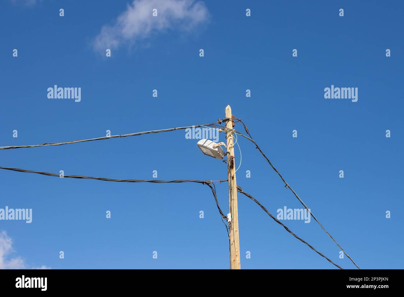 Wooden traditional pole for a rather modern light. Cables on the both ...