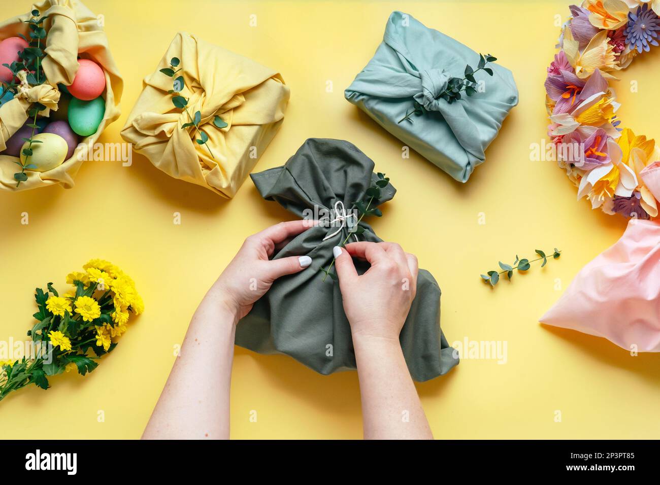 Wrapping a gift in eco friendly reusable fabric package Stock Photo - Alamy