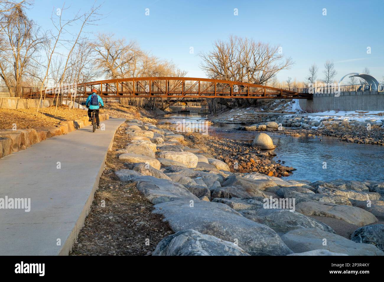 male cyclist is riding a bike in winter sunset scenery - Poudre River ...
