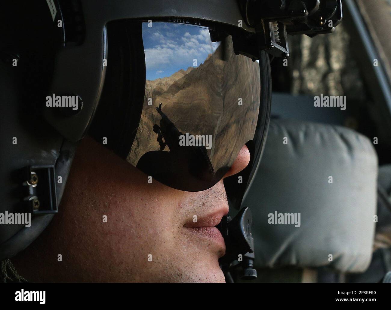 A US Army window gunner holds his weapon on a helicopter carrying U.S ...