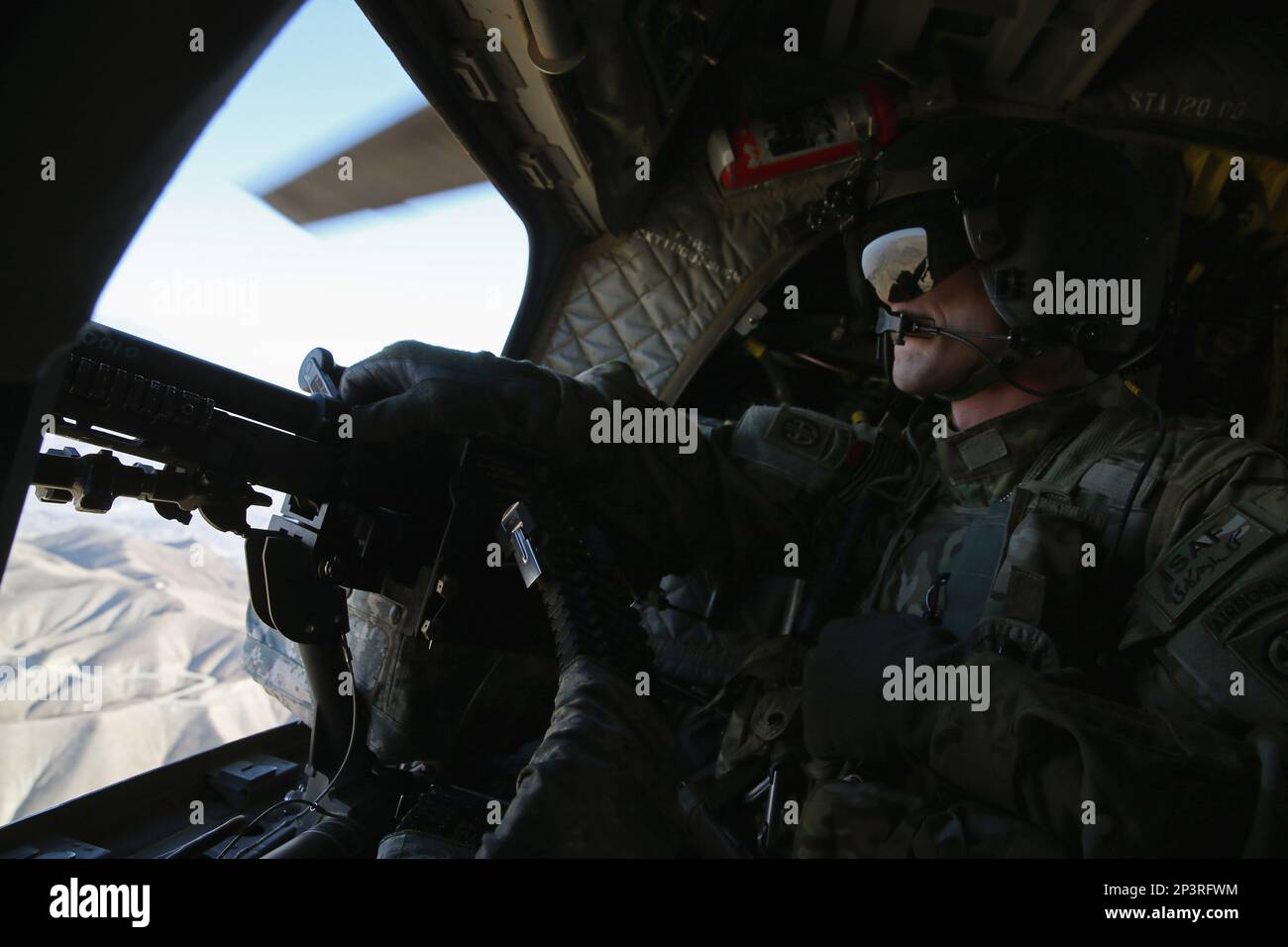 A US Army window gunner holds his weapon on a helicopter carrying U.S ...