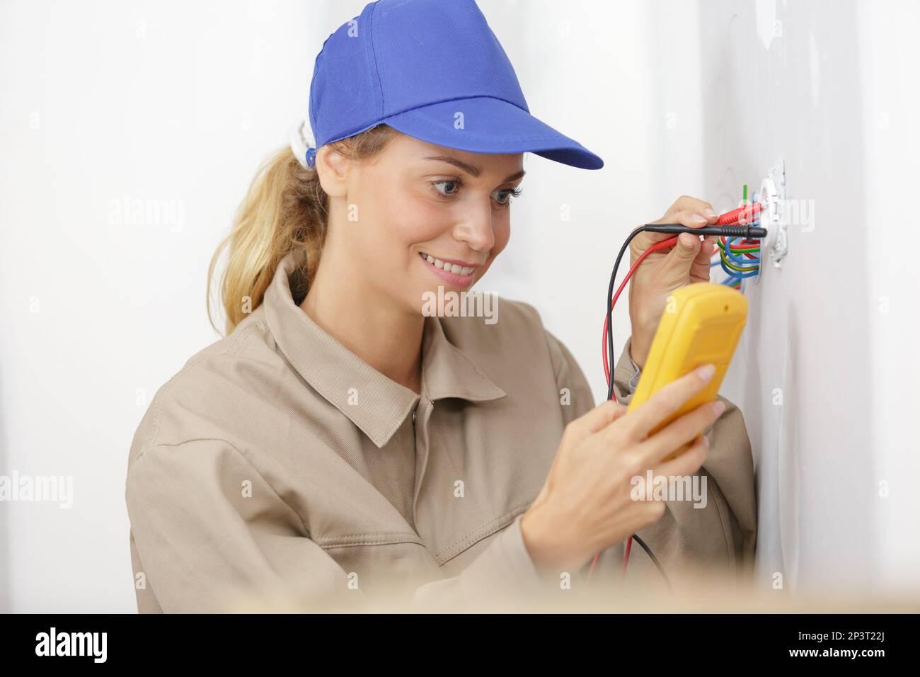 female electrician testing socket using a multimeter Stock Photo - Alamy