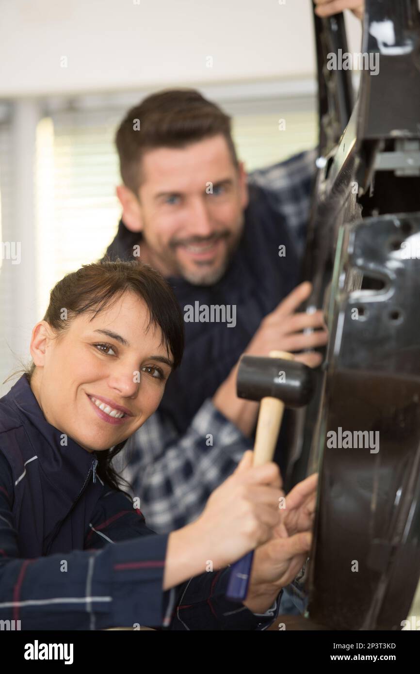 male and female panelbeaters working on a car door Stock Photo - Alamy