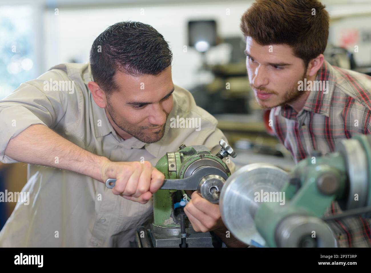 engineer exerting effort to turn component on machine Stock Photo - Alamy