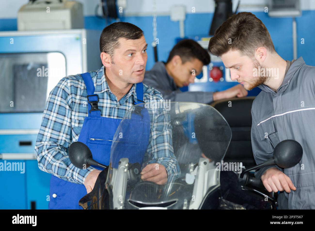 mechanic repairing a motorcycle in a workshop Stock Photo - Alamy