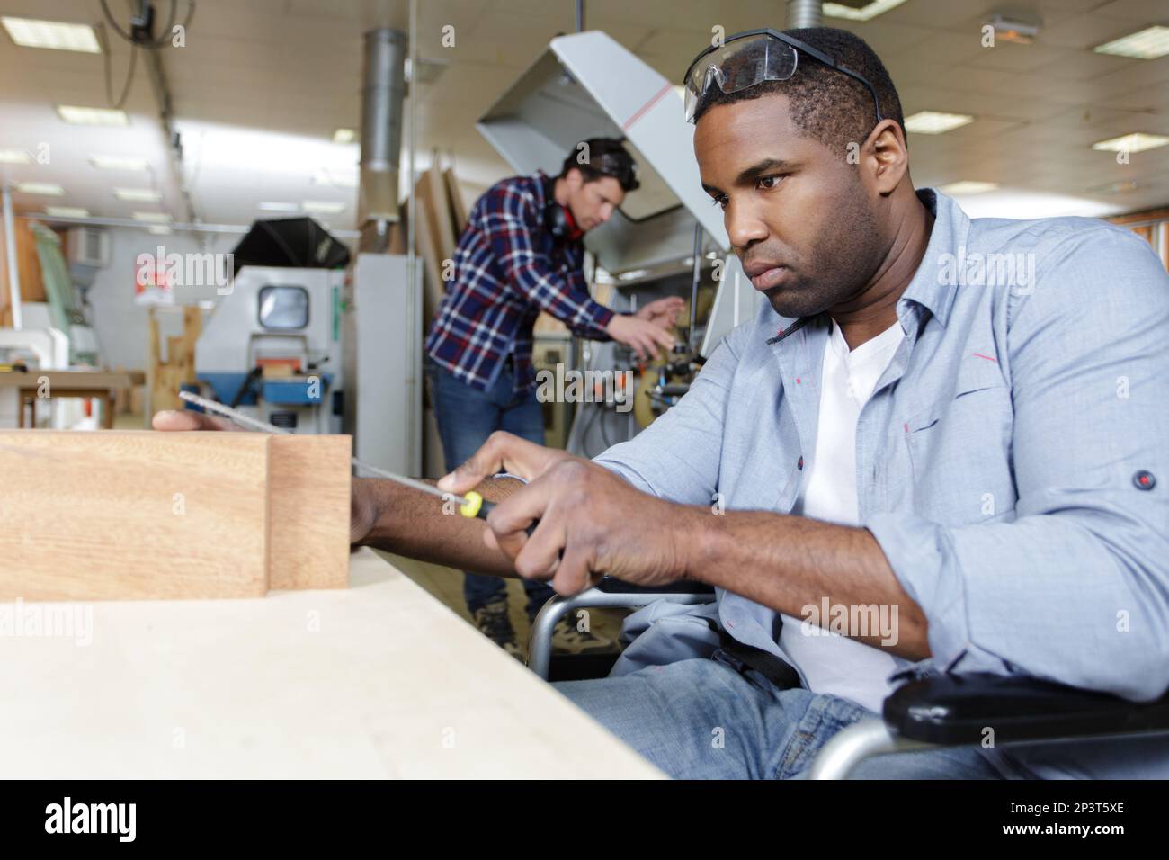 disabled worker in wheelchair in a carpenters workshop Stock Photo - Alamy