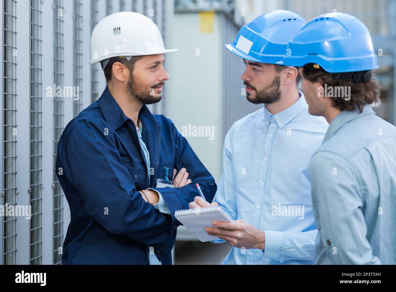 three engineers checking plans with documents at construction site ...