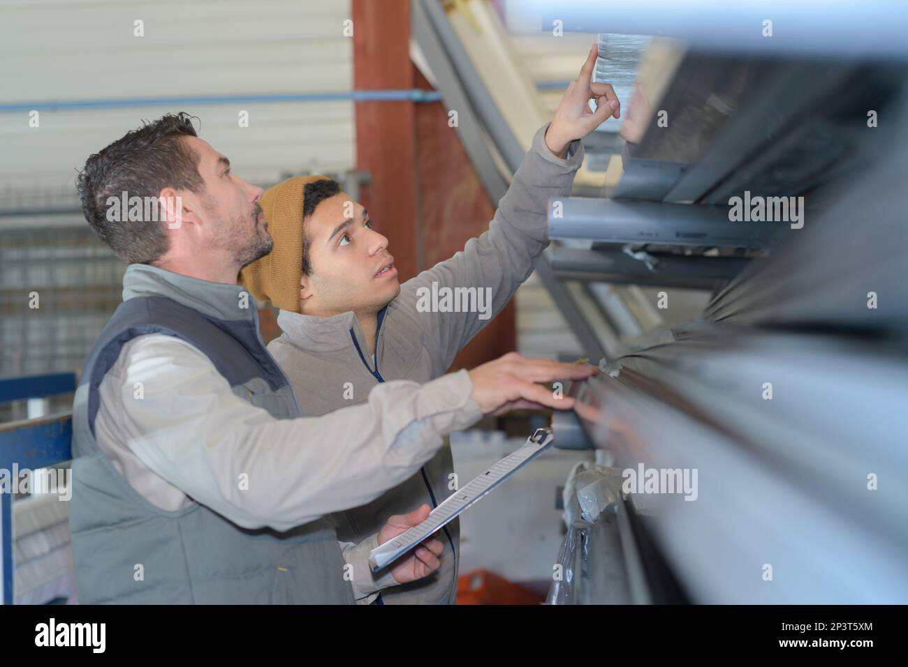 workers with clipboard checking stock of pvc pipes Stock Photo - Alamy