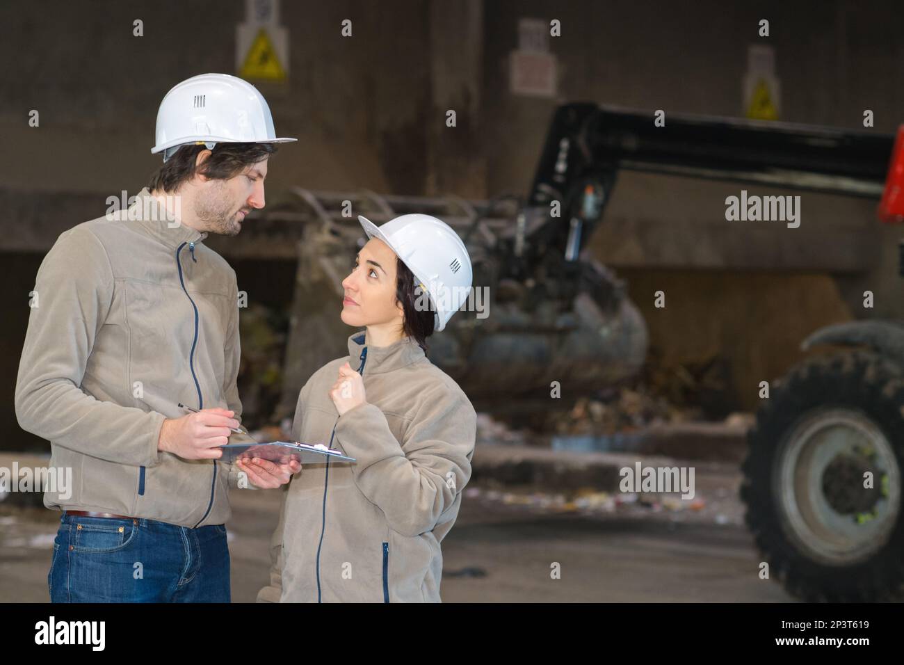 two experienced workers supervising in the interior of a factory Stock Photo - Alamy