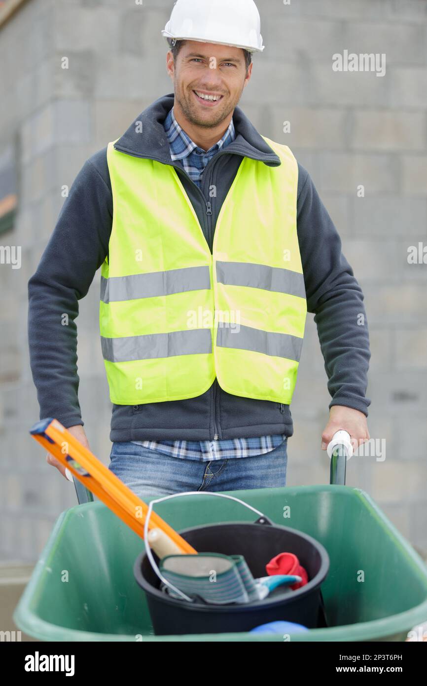 construction worker transporting tools in a wheelbarrow Stock Photo - Alamy