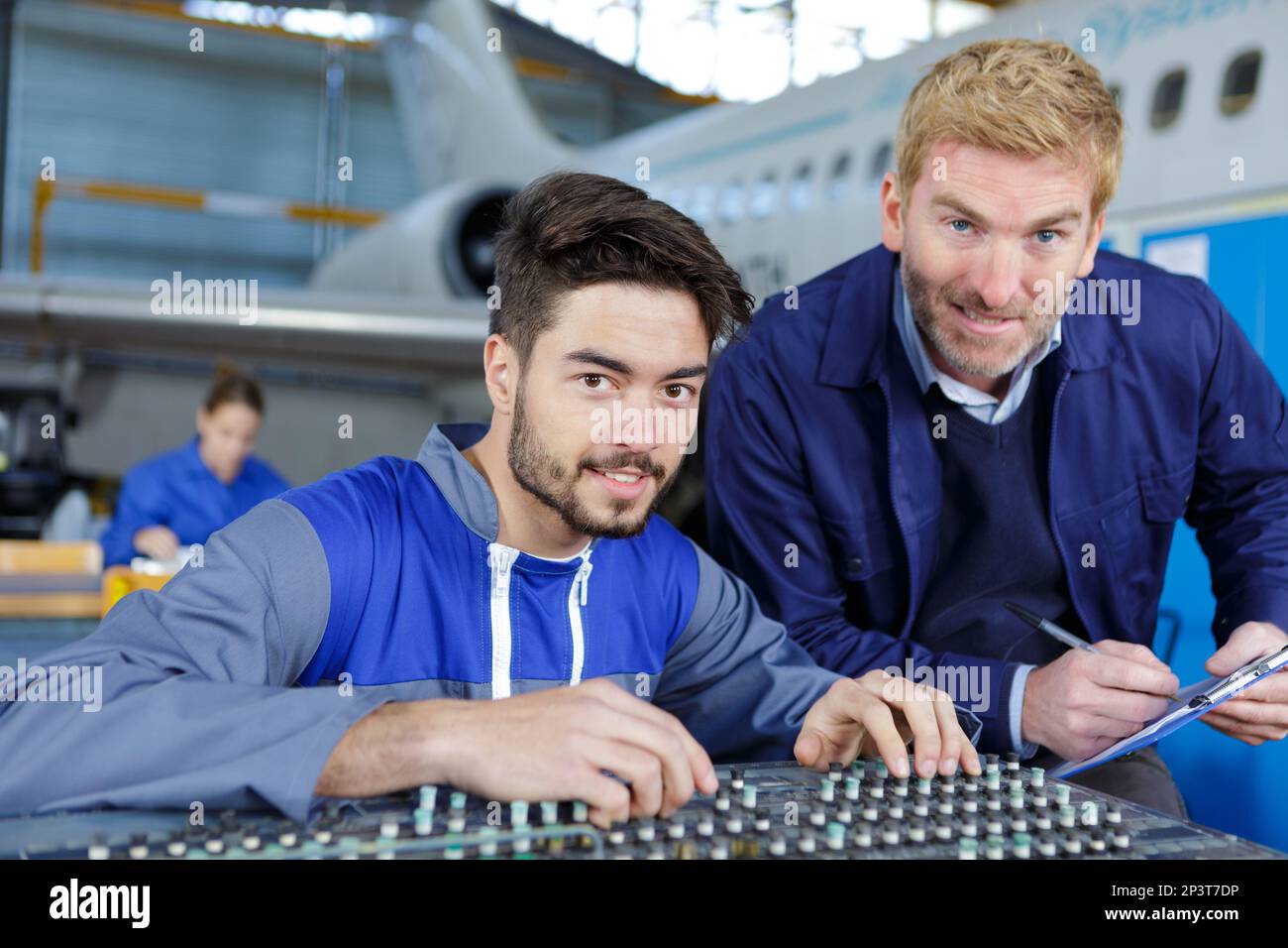 two mechanics working on a small aircraft in a hangar Stock Photo - Alamy