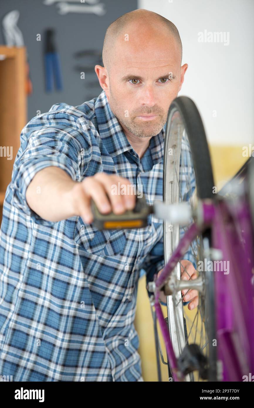 man checking the bikes wheel alignment Stock Photo - Alamy