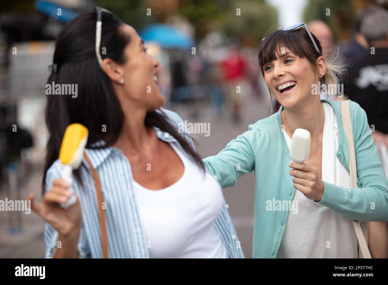 two young female friends having fun and eating ice cream Stock Photo ...