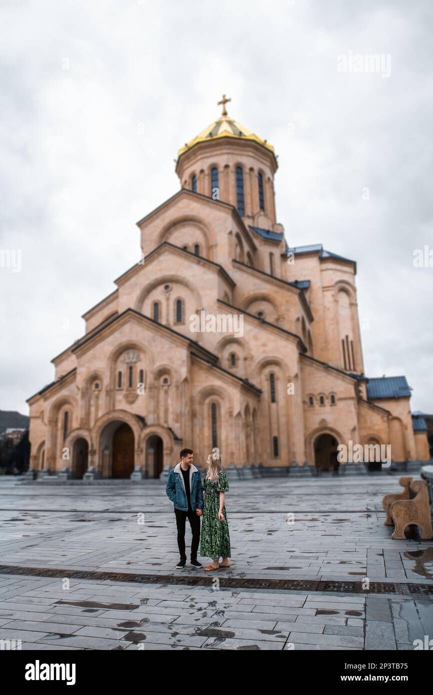 A couple outside The Holy Trinity Cathedral of Tbilisi (Tsminda Sameba ...