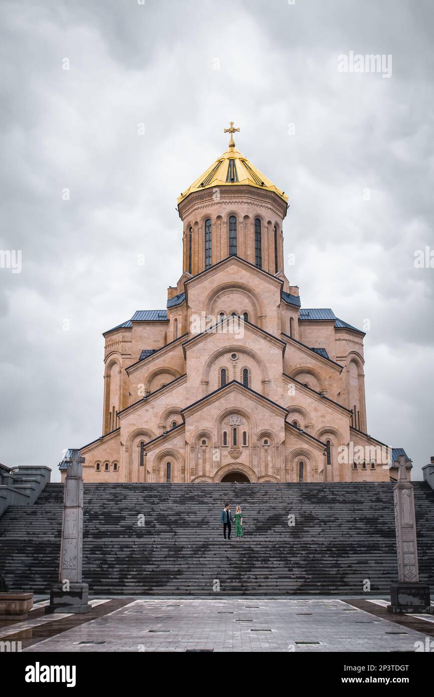 A couple outside The Holy Trinity Cathedral of Tbilisi (Tsminda Sameba ...