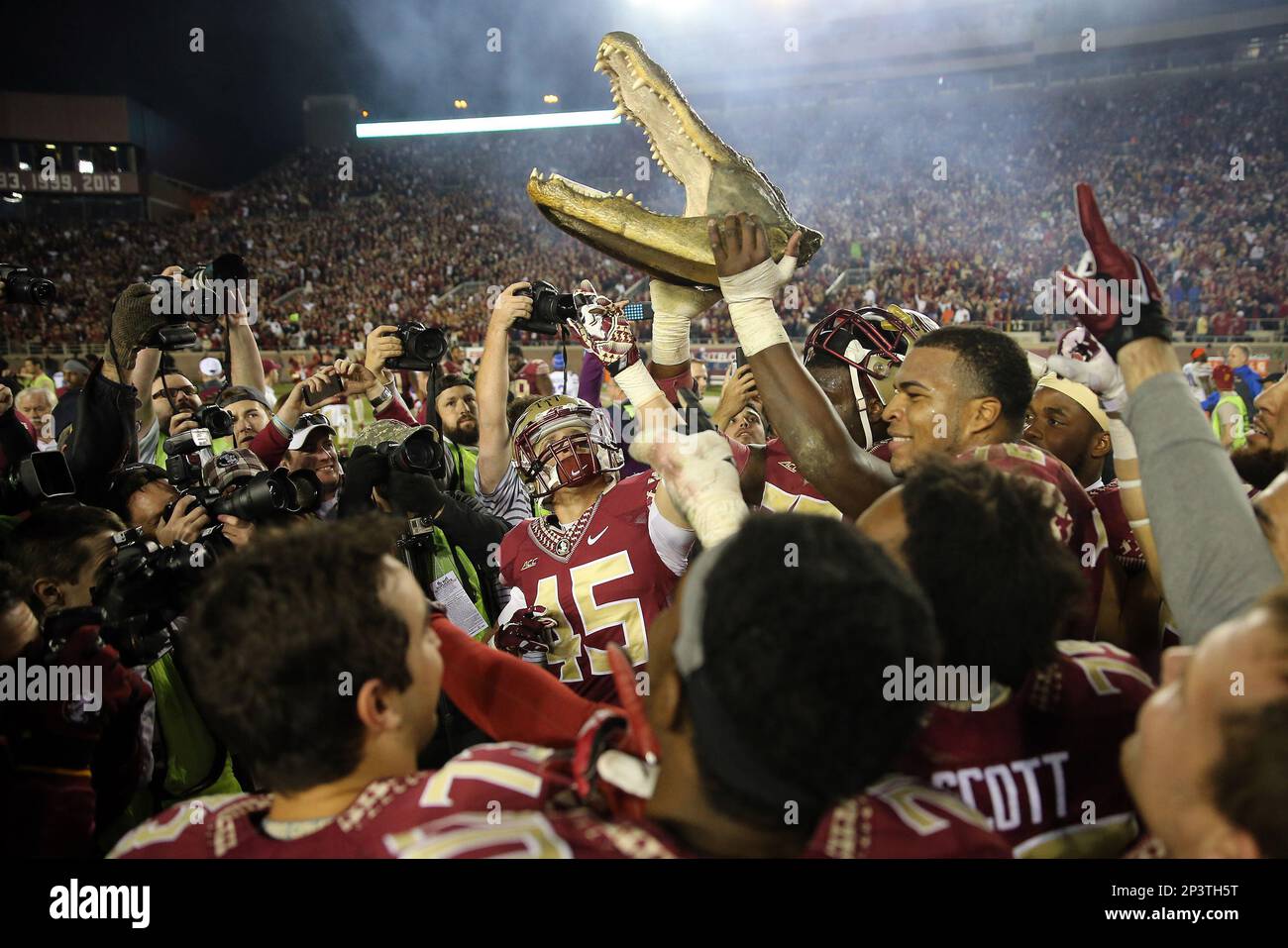 Florida Seminole football players hold up an alligator head after ...