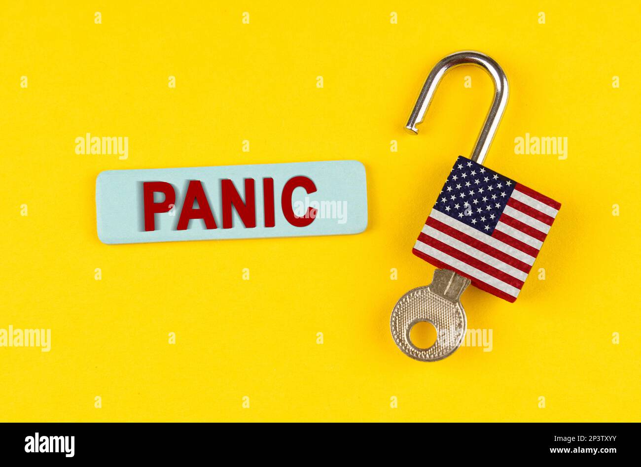 On a yellow surface, an open lock with the image of the US flag with a ...