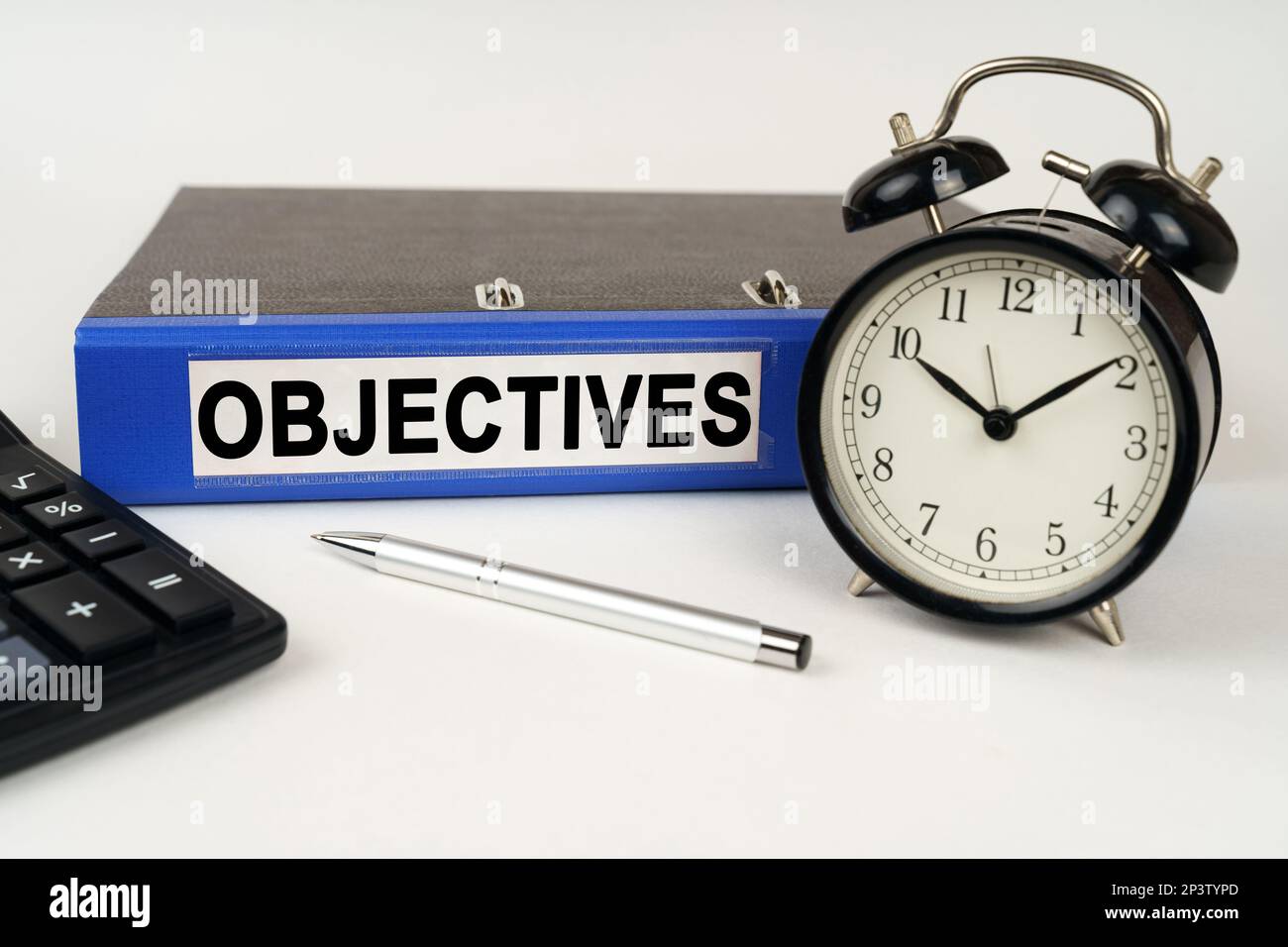 Business concept. On a white surface, an alarm clock calculator and a ...