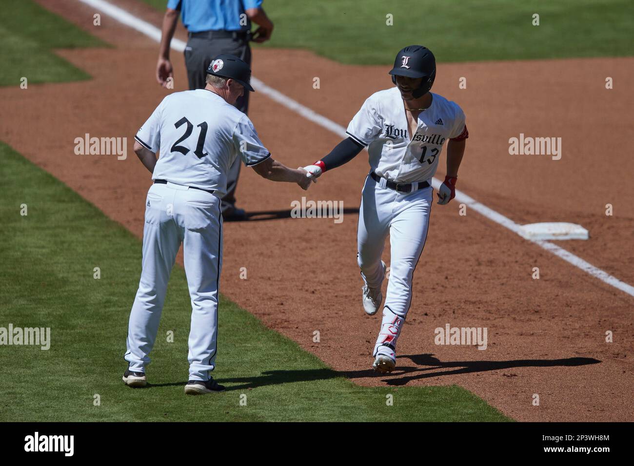 JT Benson (13) of the Louisville Cardinals shakes hands with third base ...