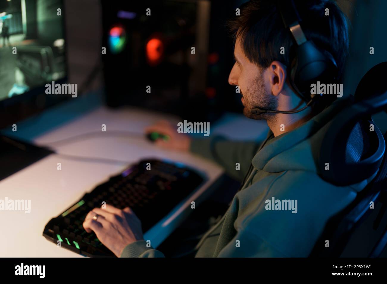 Male gamer using desktop while playing video game Stock Photo - Alamy
