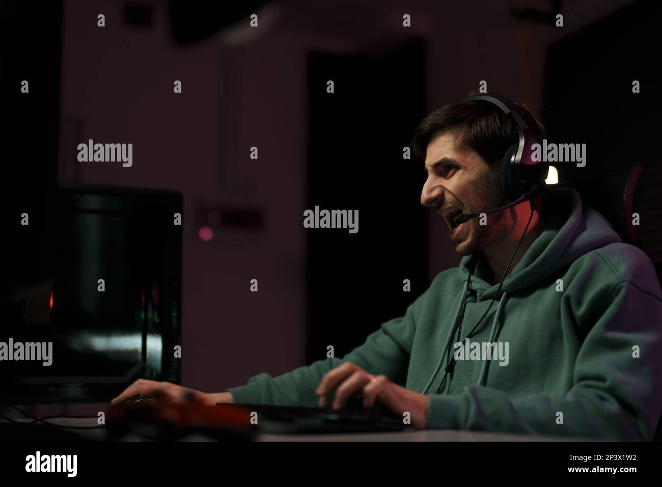 Male cybersport gamer screaming while playing video game Stock Photo ...