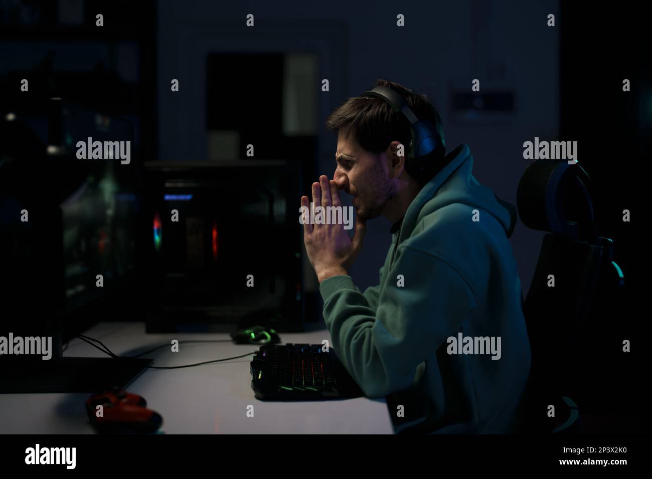 Male cybersport gamer sitting with prayer hands Stock Photo - Alamy