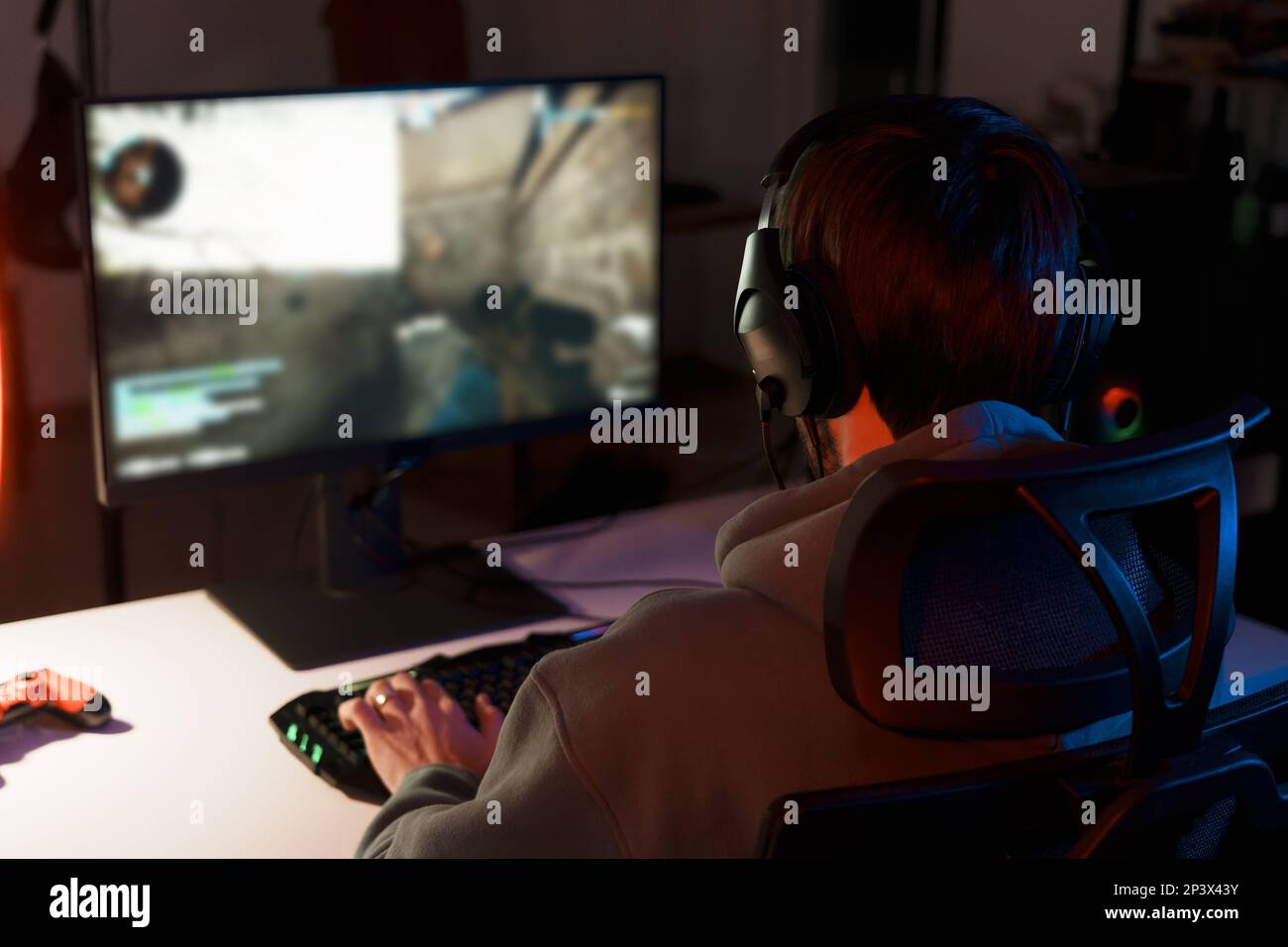Male gamer using desktop while playing video game Stock Photo - Alamy