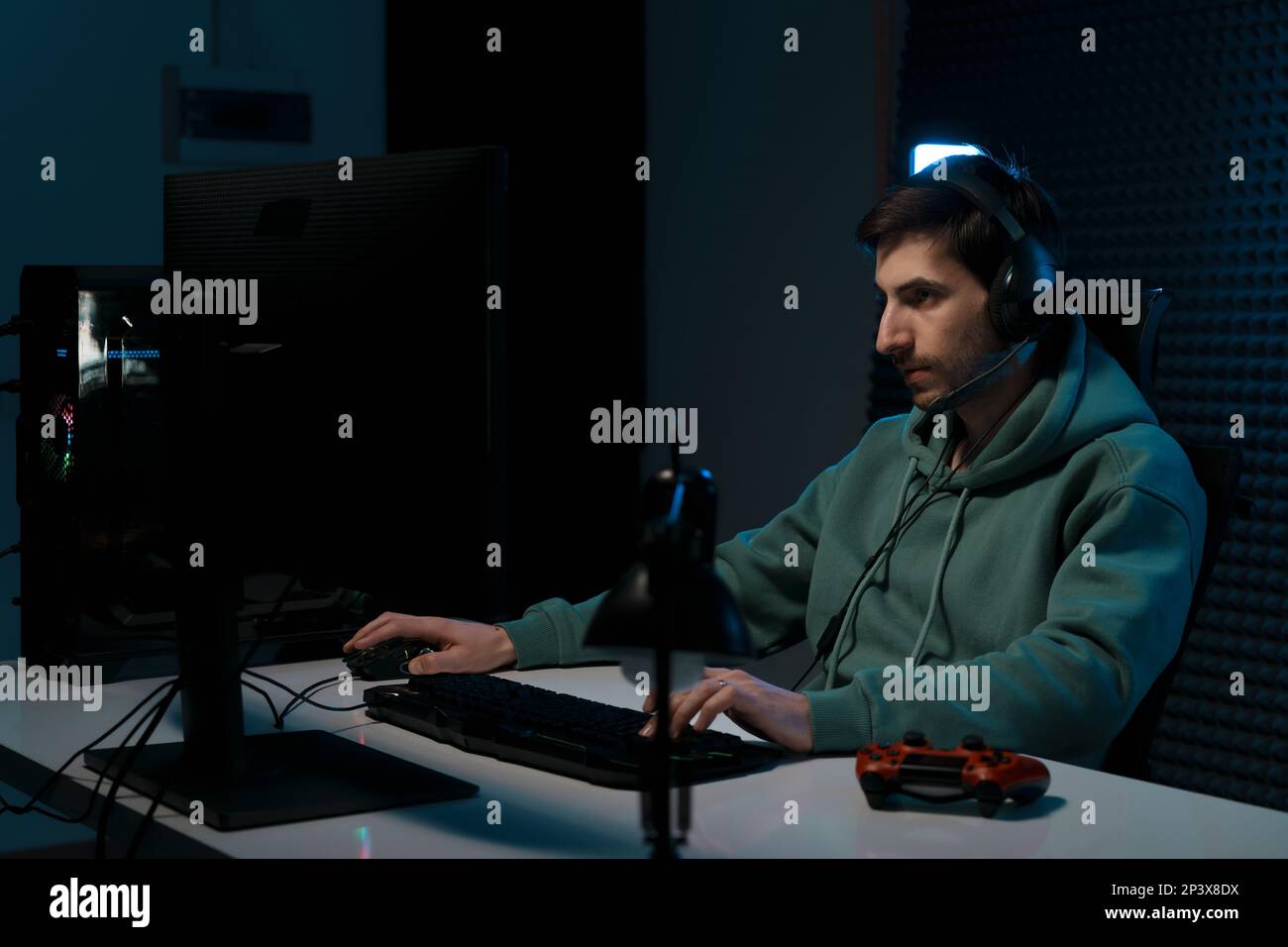 Male gamer wearing headset while gaming at home Stock Photo - Alamy
