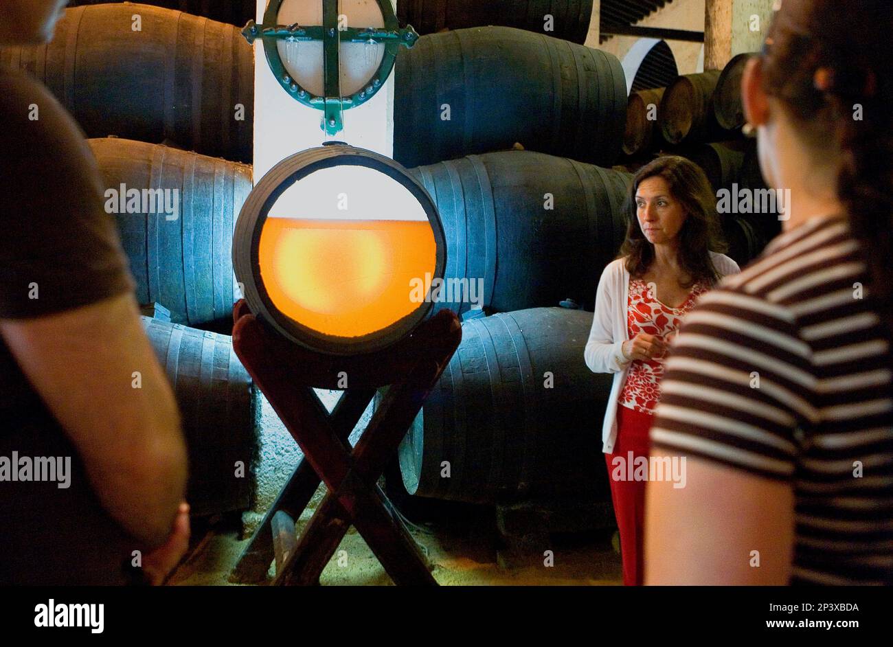 Guide and tourists in front of a barrel that shows the process of ...