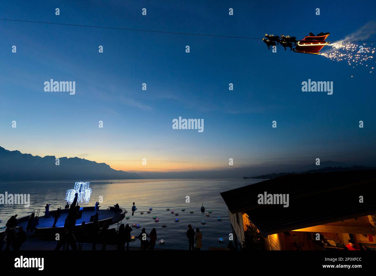 Santa Claus waves to the crowd from his flying sleigh drawn by reindeer ...