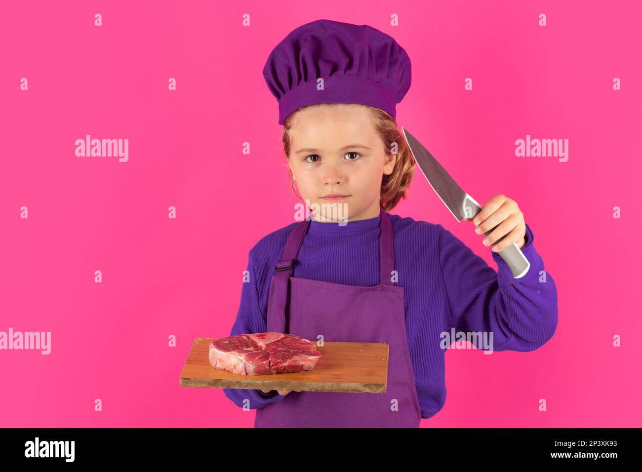 Child cook hold cutting board with meat beef steak and knife. Portrait ...