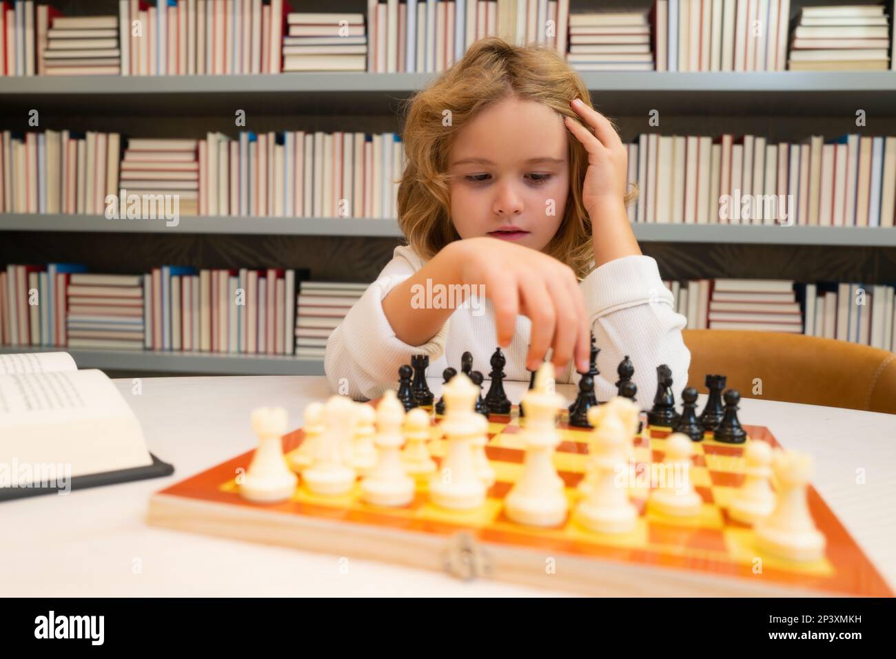Kid thinking of chess. Little child chessman play chess game, checkmate ...