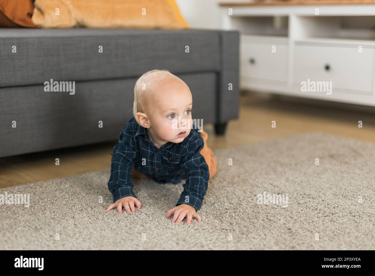 Nursery baby boy crawling on floor indoors at home copy space and empty ...