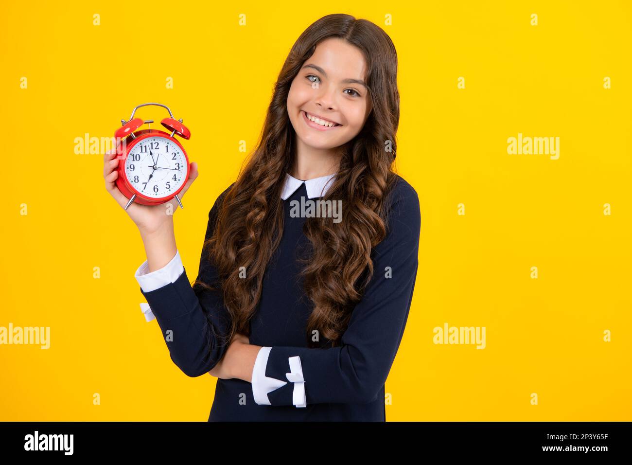 Teen student girl hold clock isolated on yellow background. Time to ...