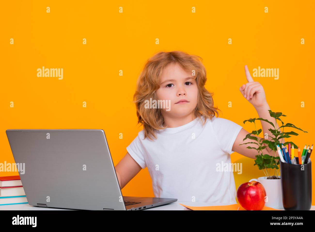 School child using laptop computer. School kid holding index finger up ...