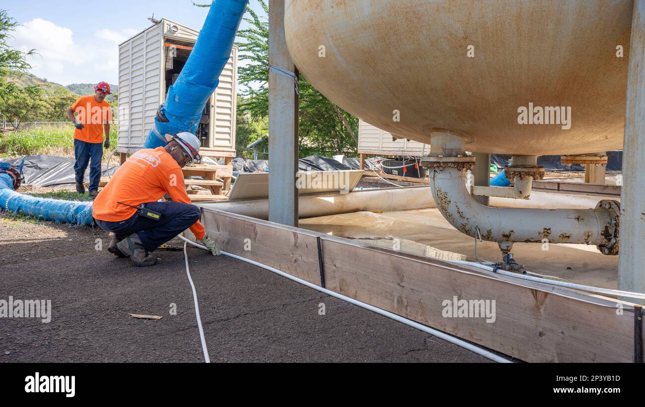 A supervisor and a foreman attach an outside pipe from the water tank ...