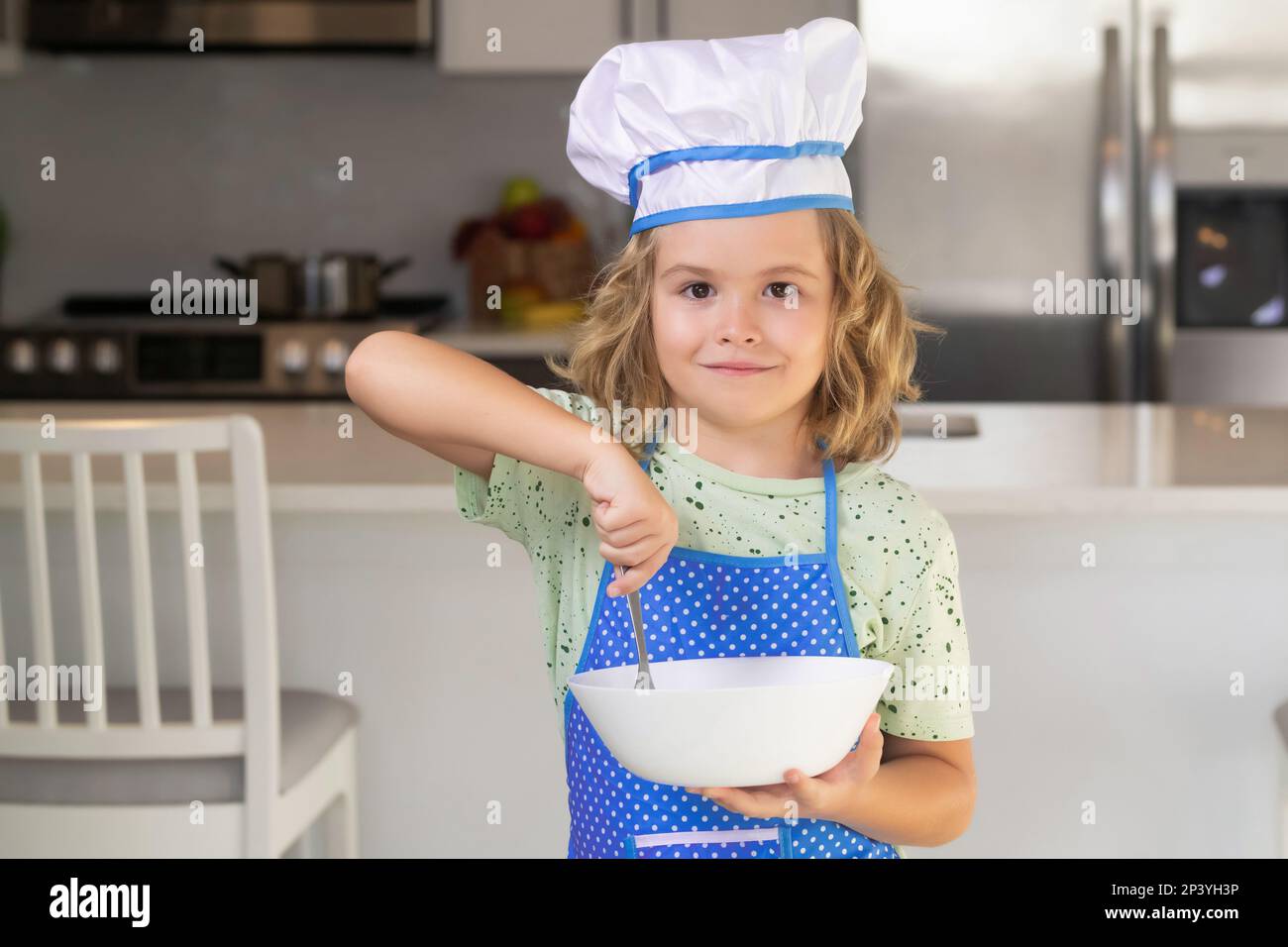 Child chef cook with cooking plate. Children cooking in the kitchen ...