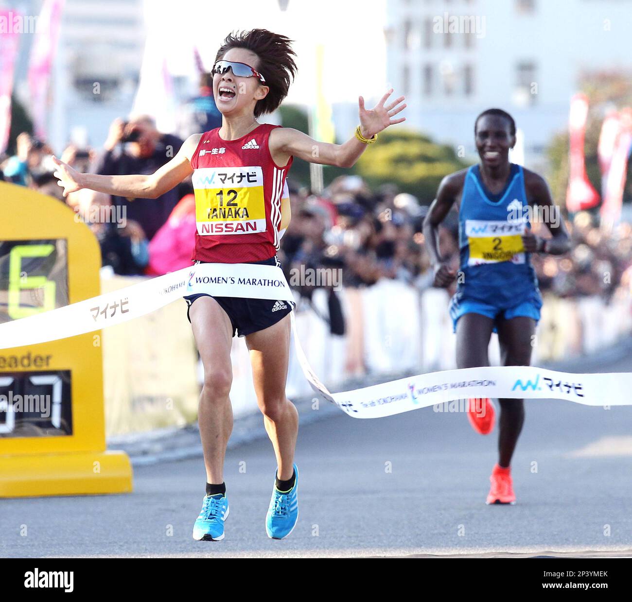 Japan's Tomomi Tanaka (L) crosses the finish ling at the Yokohama ...