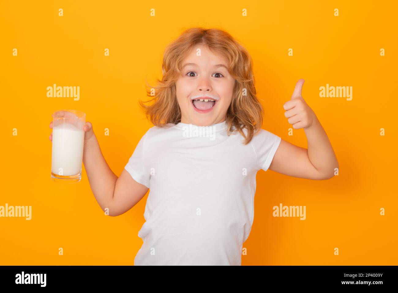 Small boy drink a glass of milk with funny emotions on yellow ...