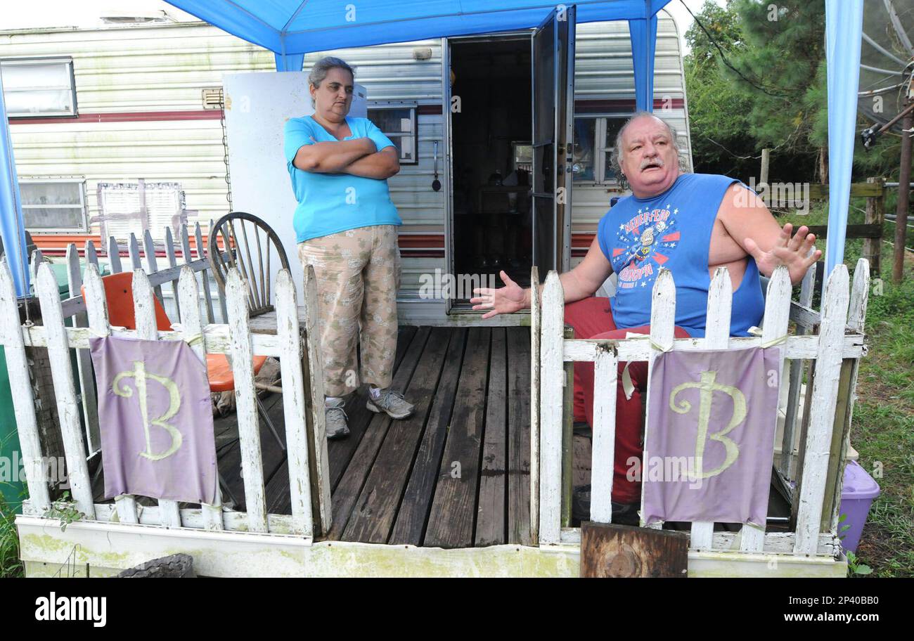 Cyndee Sell, left, and Melvin Walters sit on the porch of their trailer ...